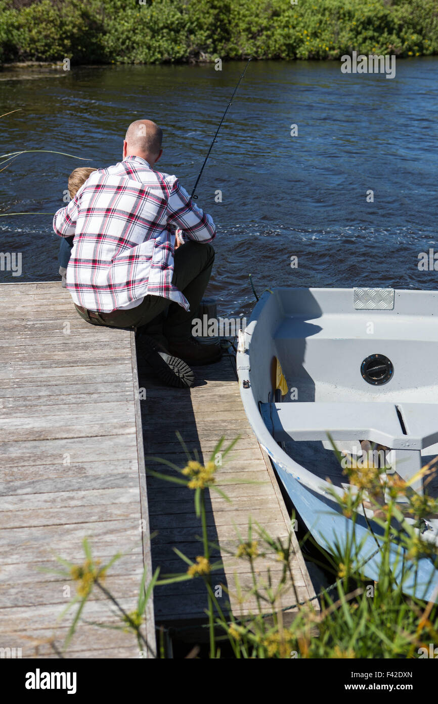Happy man fishing with his son Stock Photo - Alamy