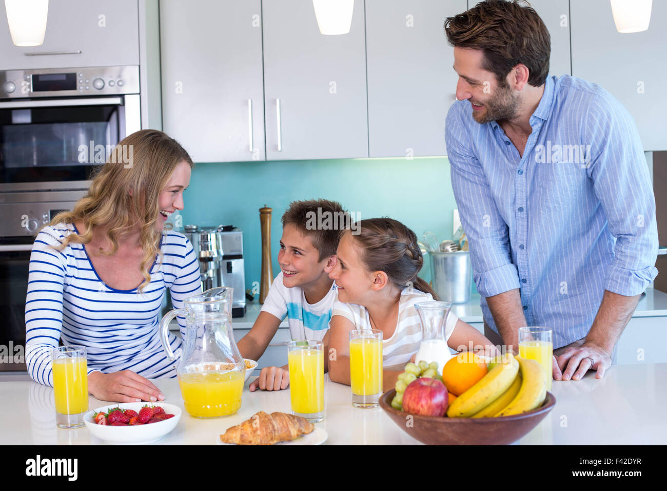 Happy family having breakfast together Stock Photo - Alamy