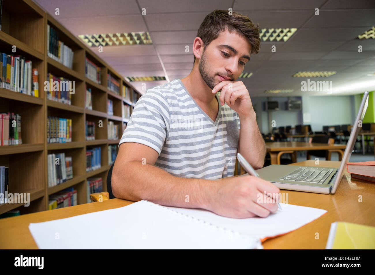 Student studying in the library with laptop Stock Photo - Alamy