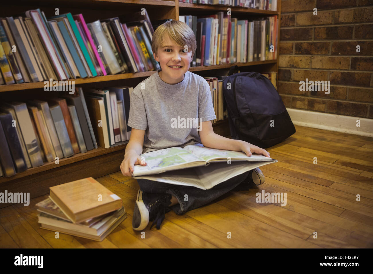 Little boy reading on library floor Stock Photo - Alamy