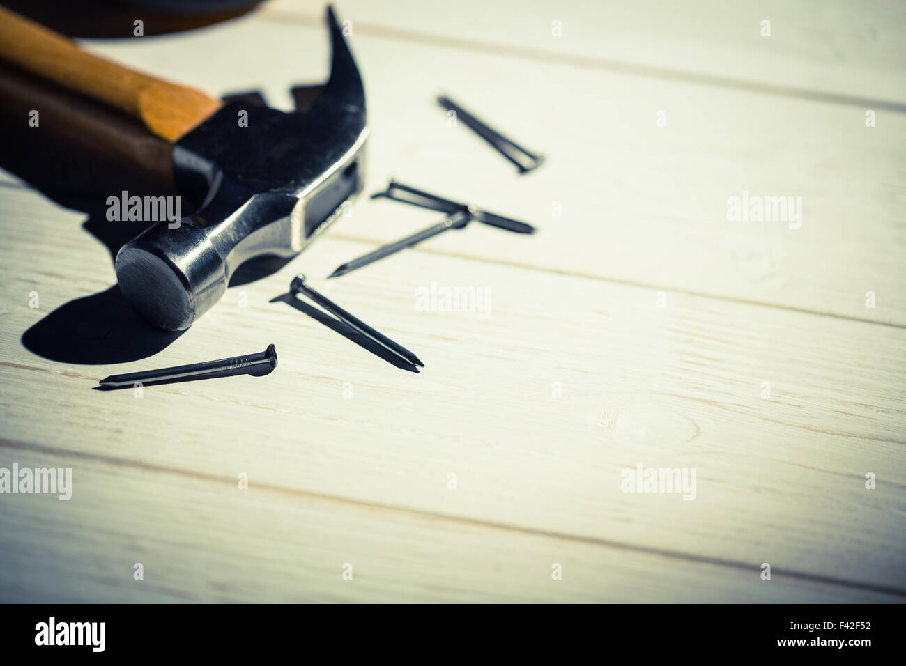 Hammer and nails laid out on table Stock Photo - Alamy