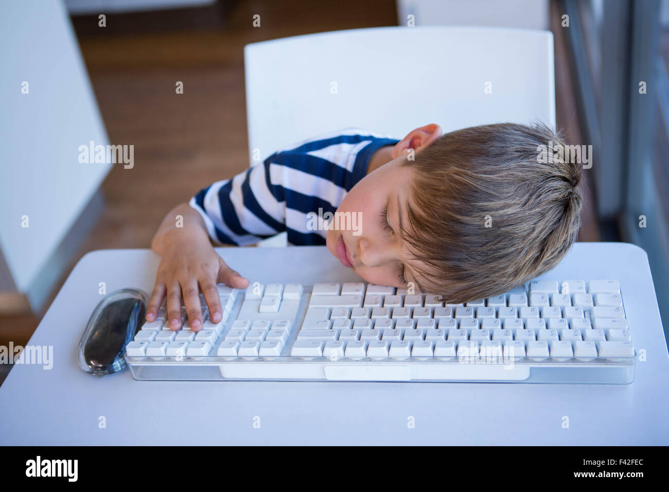 Little boy slipping on keyboard Stock Photo - Alamy