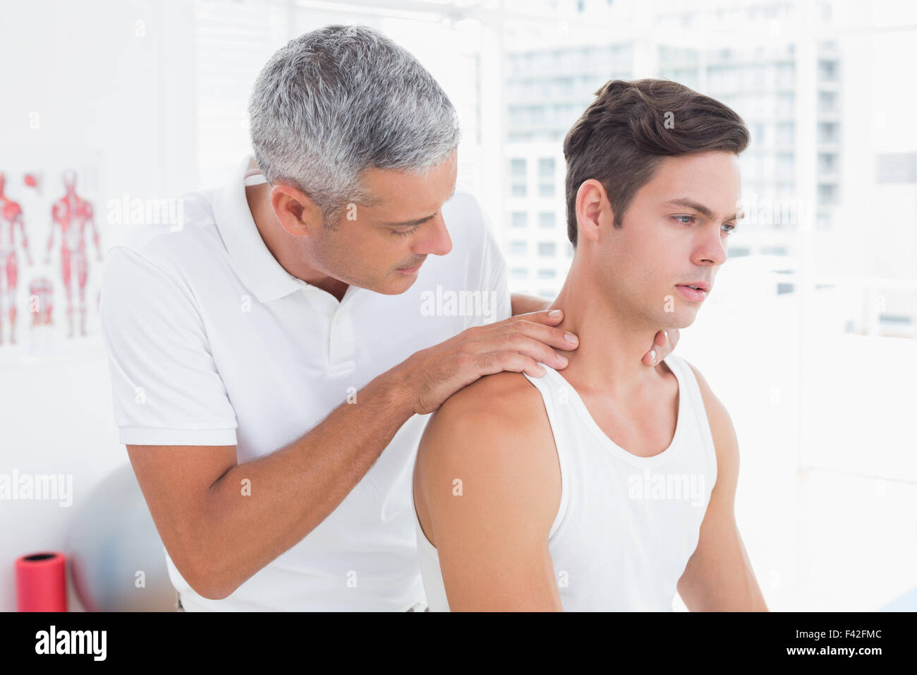 Doctor examining his patient neck Stock Photo - Alamy
