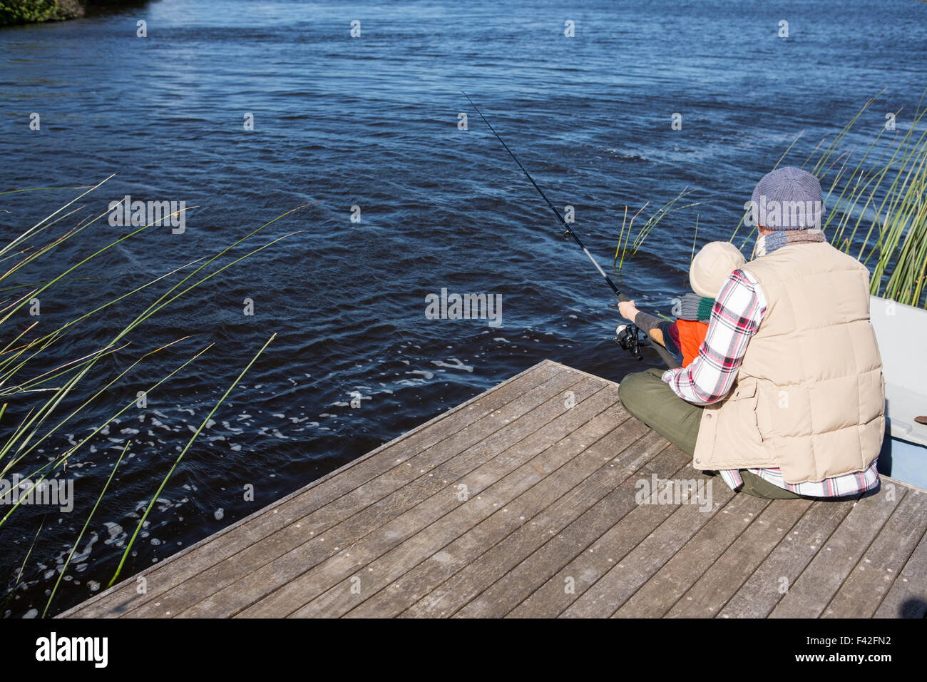 Happy man fishing with his son Stock Photo - Alamy