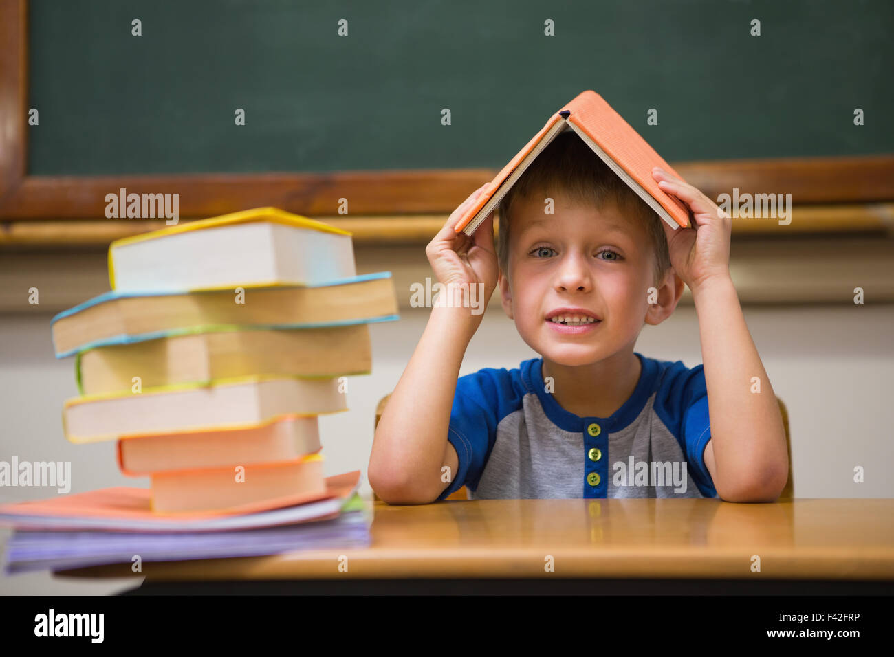 Cute boy with book on head Stock Photo - Alamy