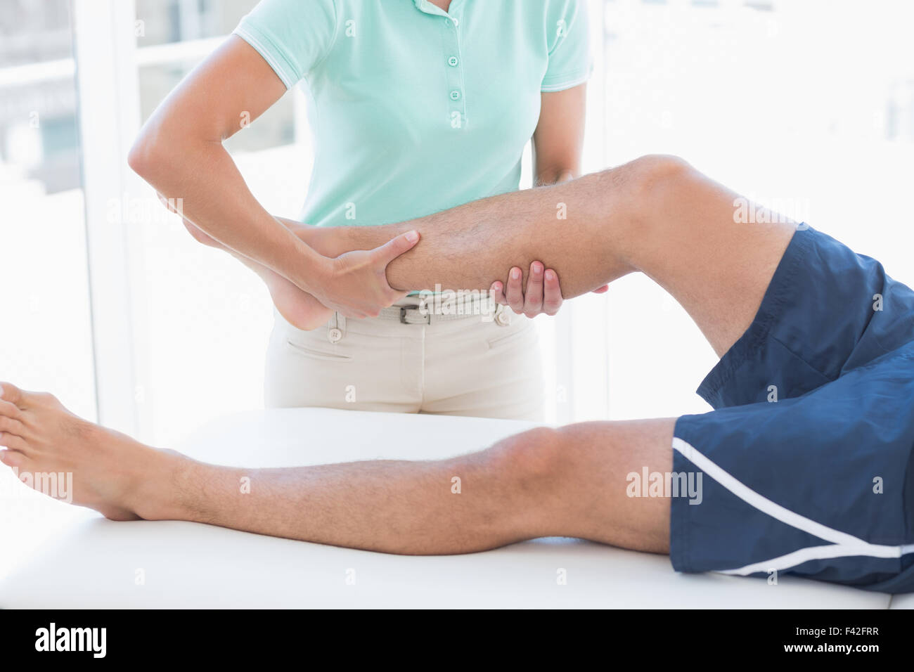 Doctor examining man leg Stock Photo - Alamy