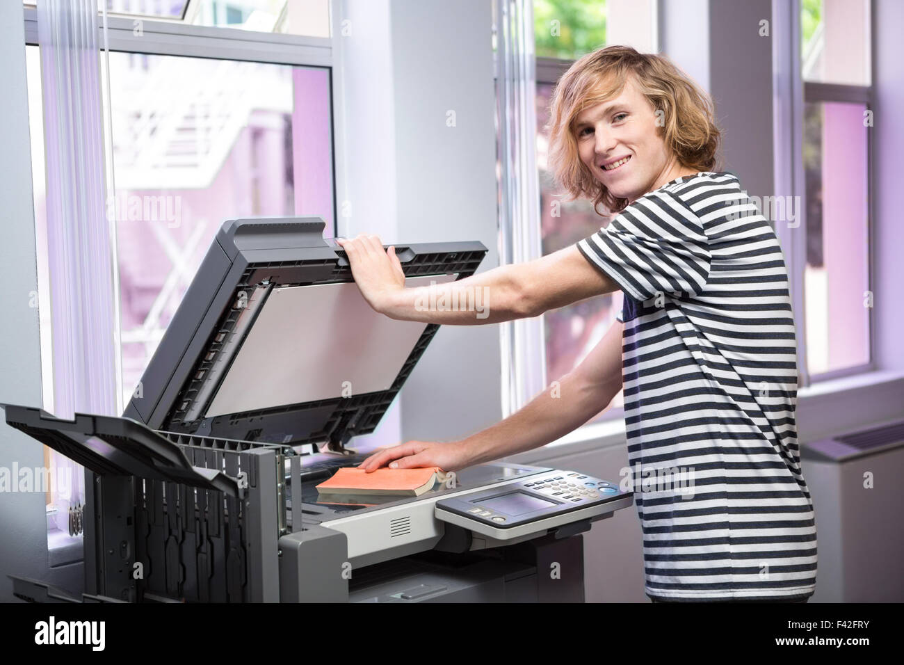 Student photocopying his book in the library Stock Photo - Alamy