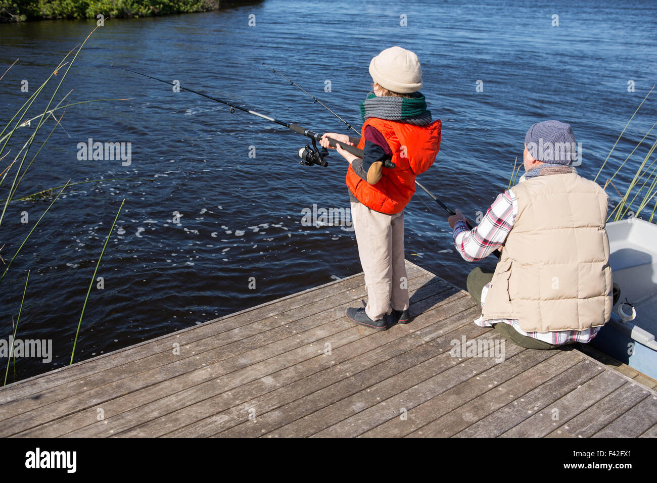 Happy man fishing with his son Stock Photo - Alamy