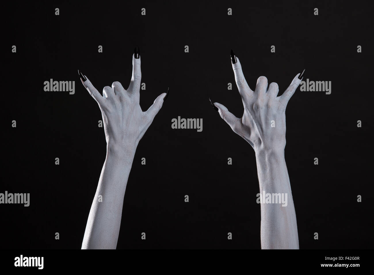 Pale ghost hands showing heavy metal sign, Halloween or music theme ...