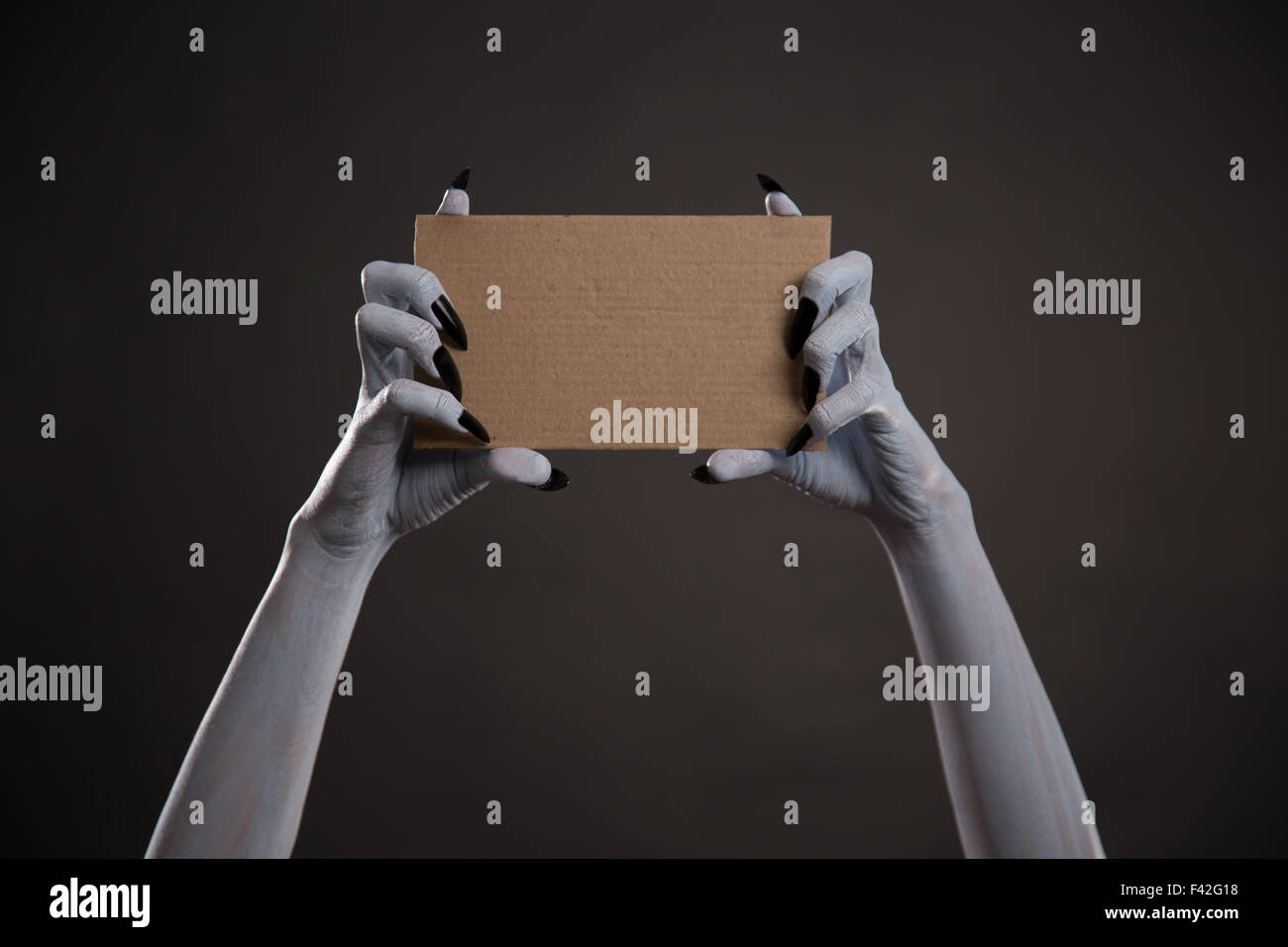 Creepy white hands with black nails holding blank cardboard, Halloween ...