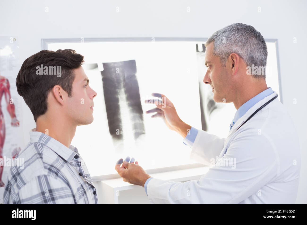 Doctor looking at X rays with his patient Stock Photo - Alamy
