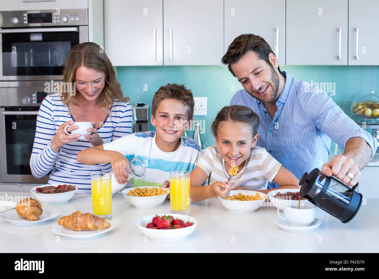 Happy family having breakfast together Stock Photo - Alamy