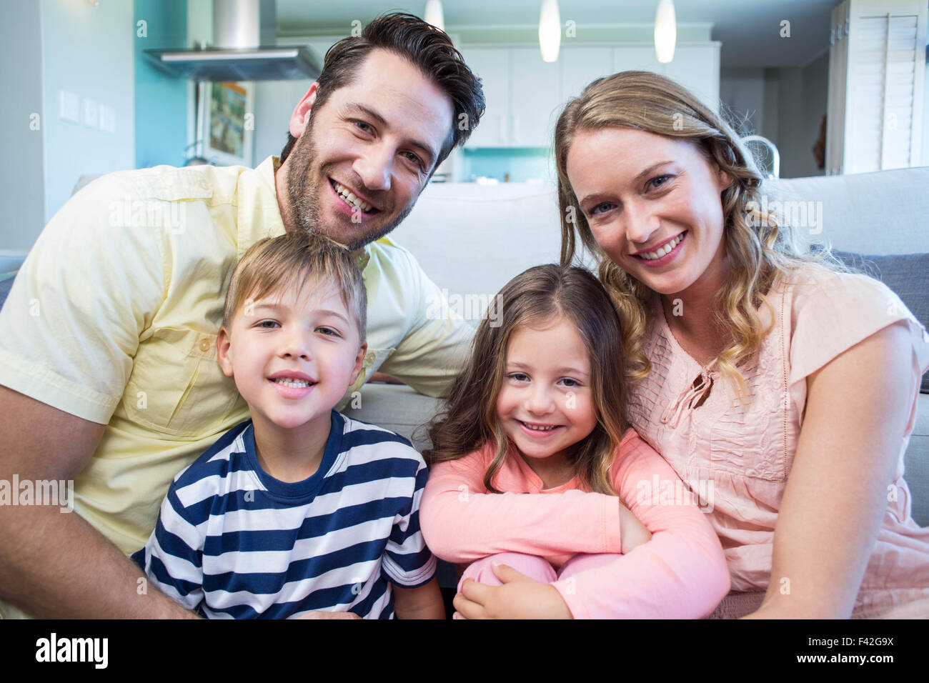 Happy family smiling at camera Stock Photo - Alamy