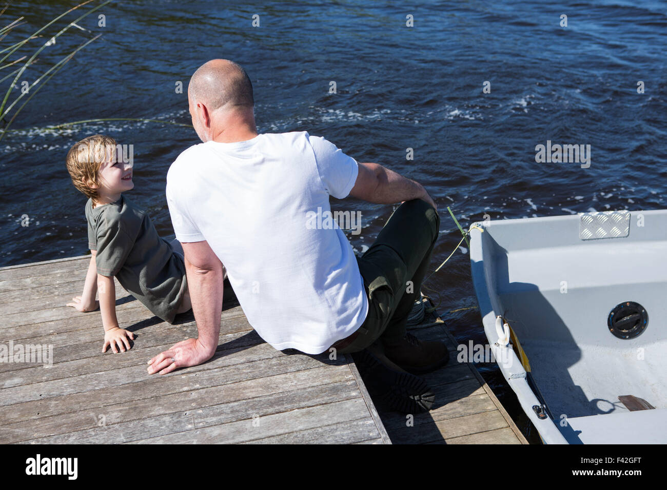 Happy man sitting with his son Stock Photo - Alamy