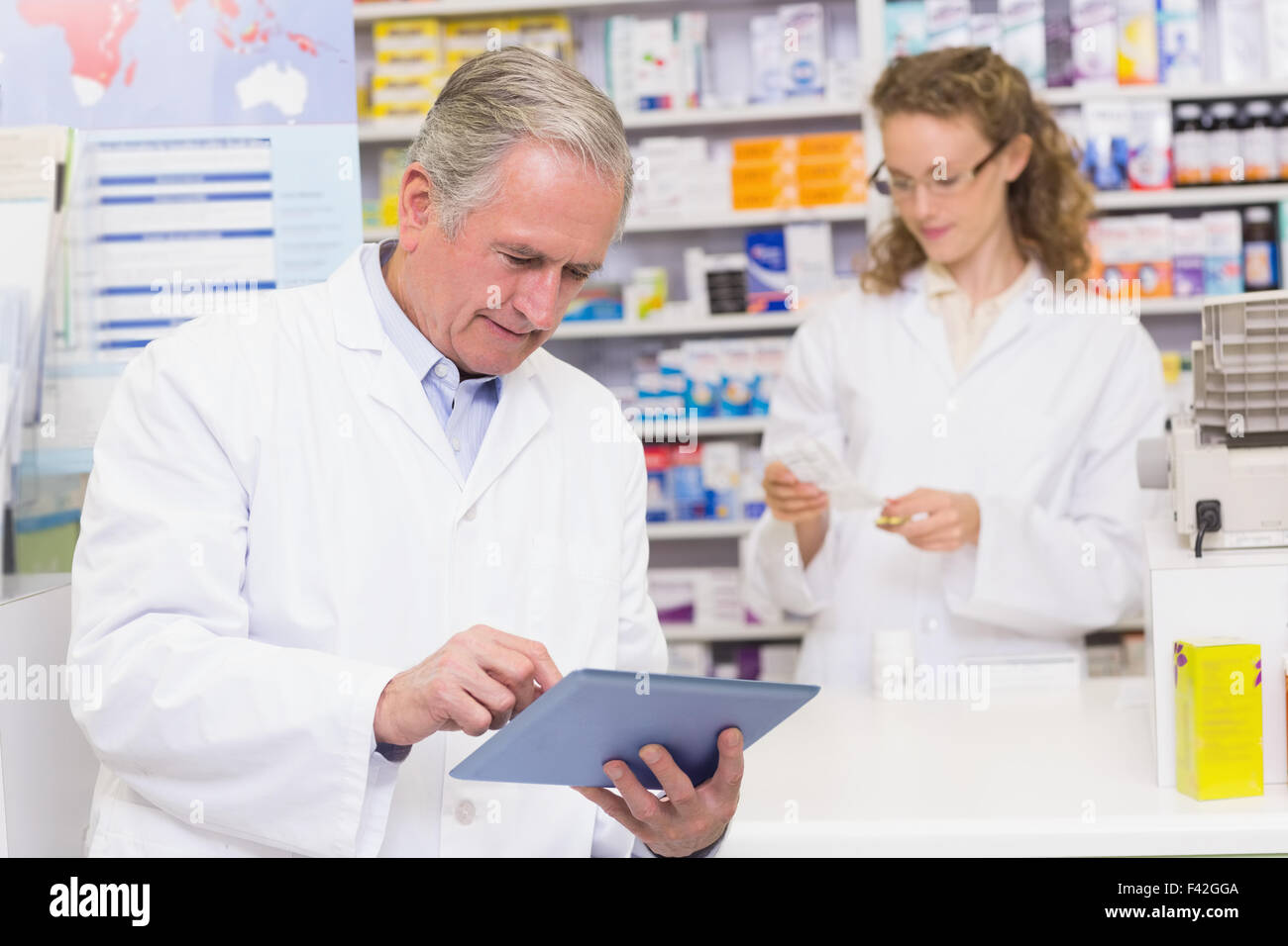 Senior pharmacist using tablet pc Stock Photo - Alamy