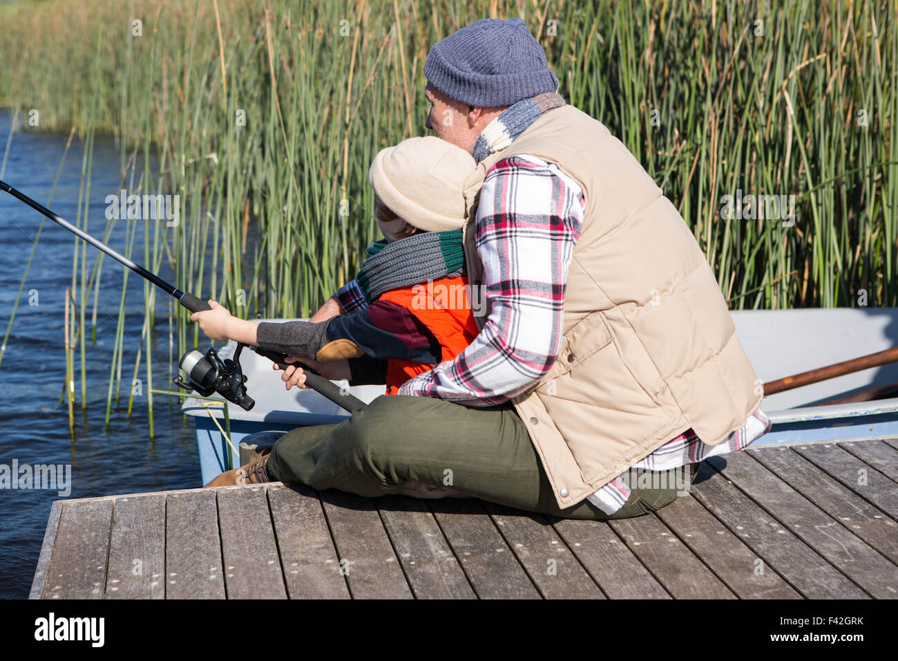 Happy man fishing with his son Stock Photo - Alamy