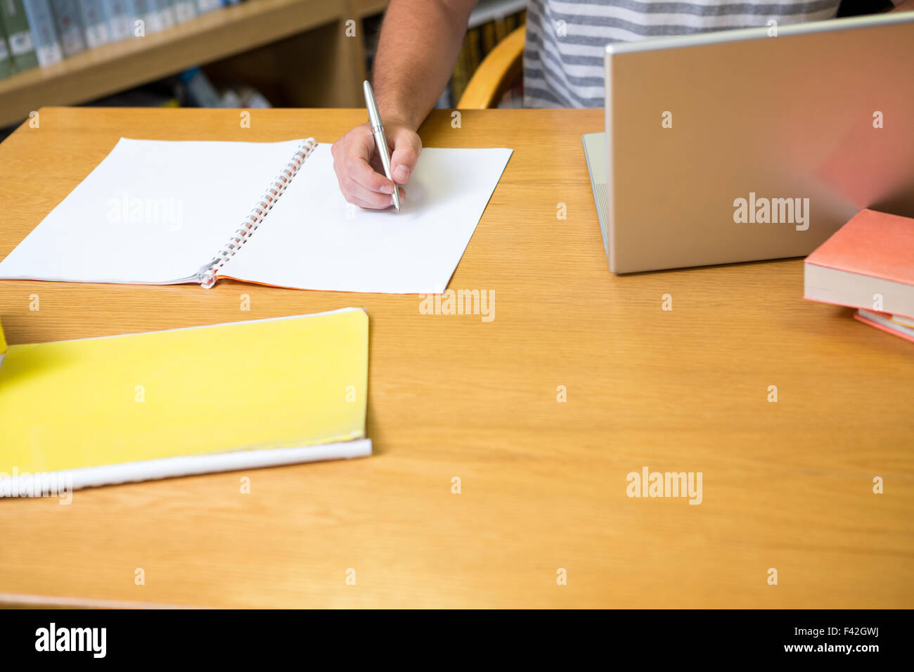 Student studying in the library with laptop Stock Photo - Alamy