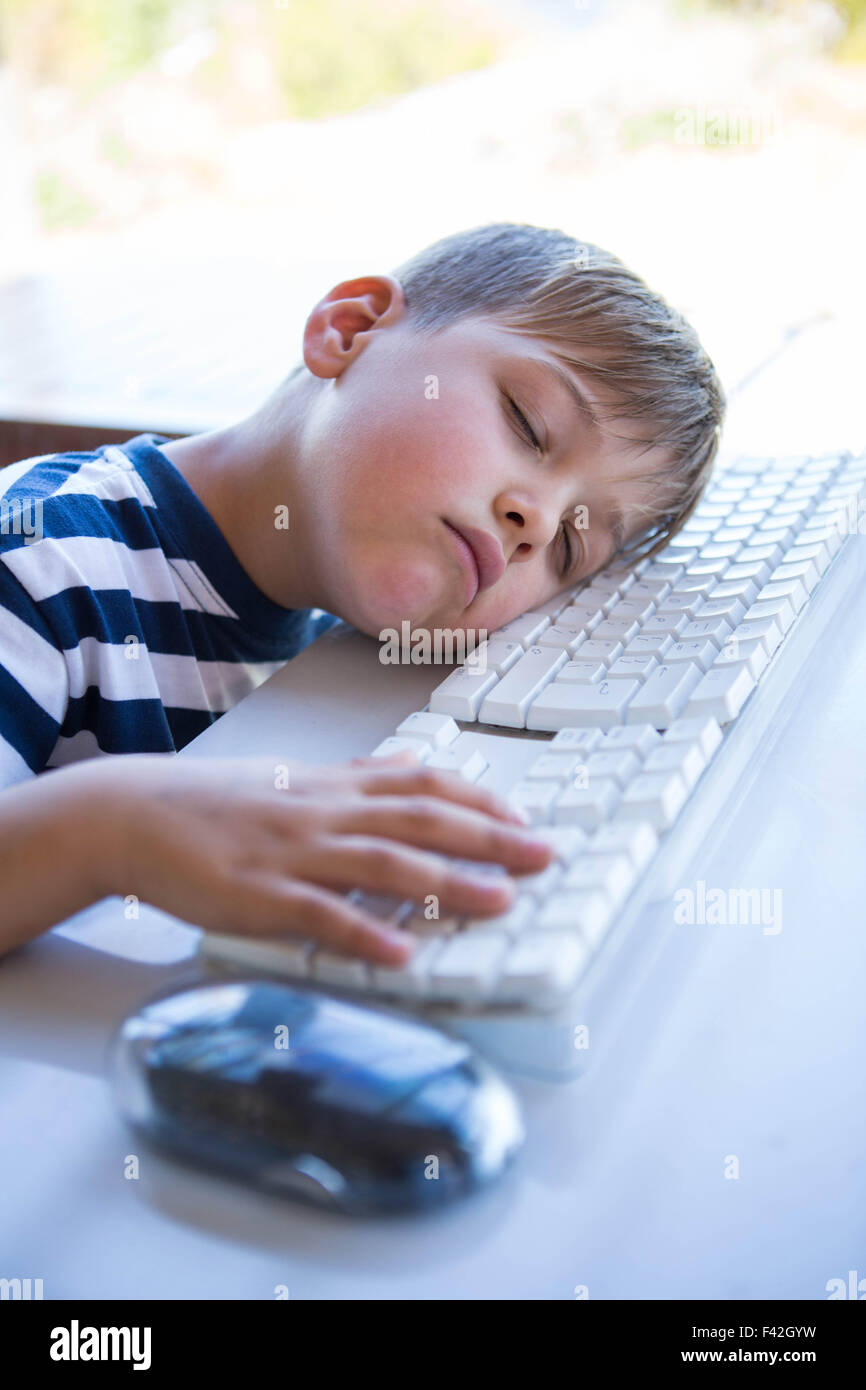 Little boy slipping on keyboard Stock Photo - Alamy