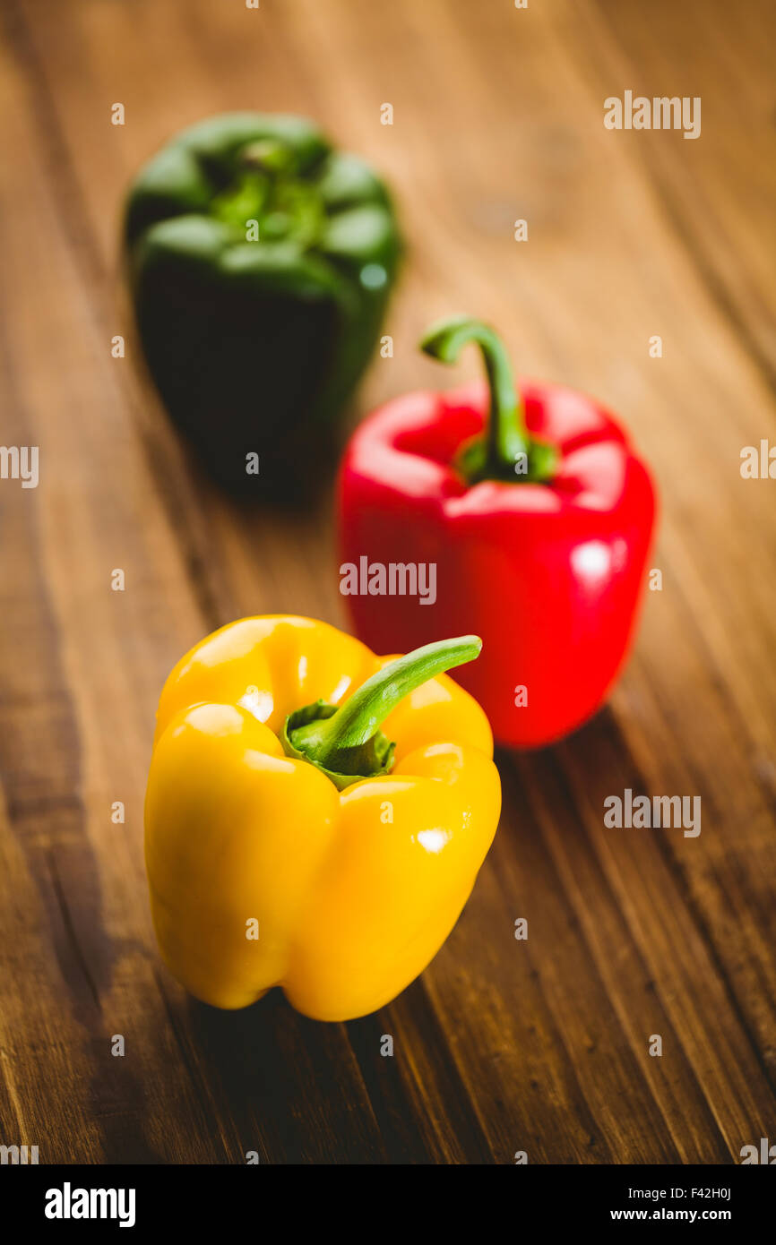 Three peppers on chopping board Stock Photo - Alamy