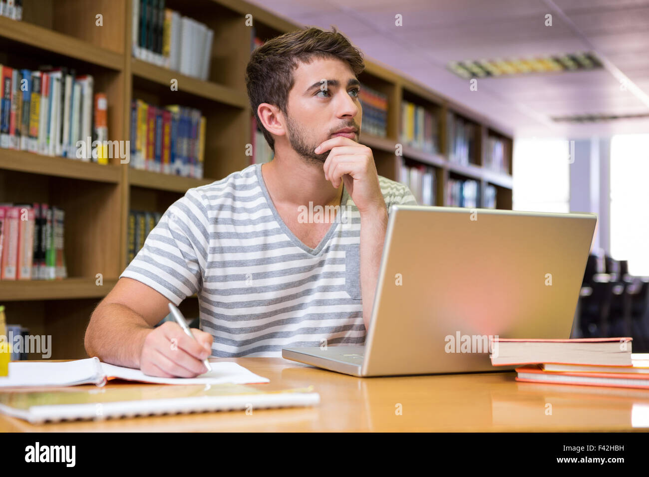 Student studying in the library with laptop Stock Photo - Alamy