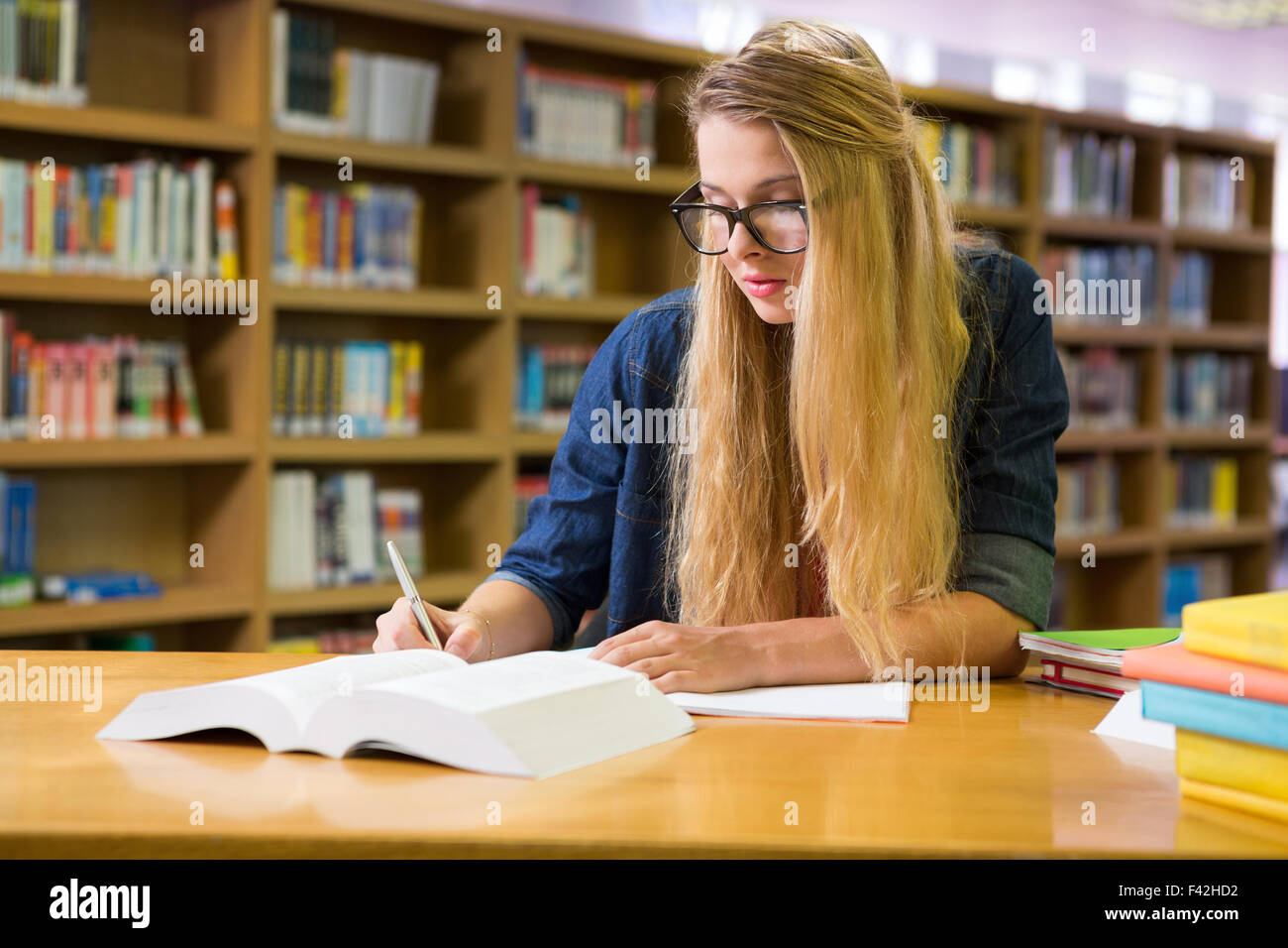 Student studying in the library Stock Photo - Alamy