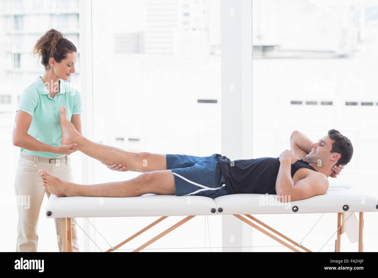 Doctor examining man leg Stock Photo - Alamy