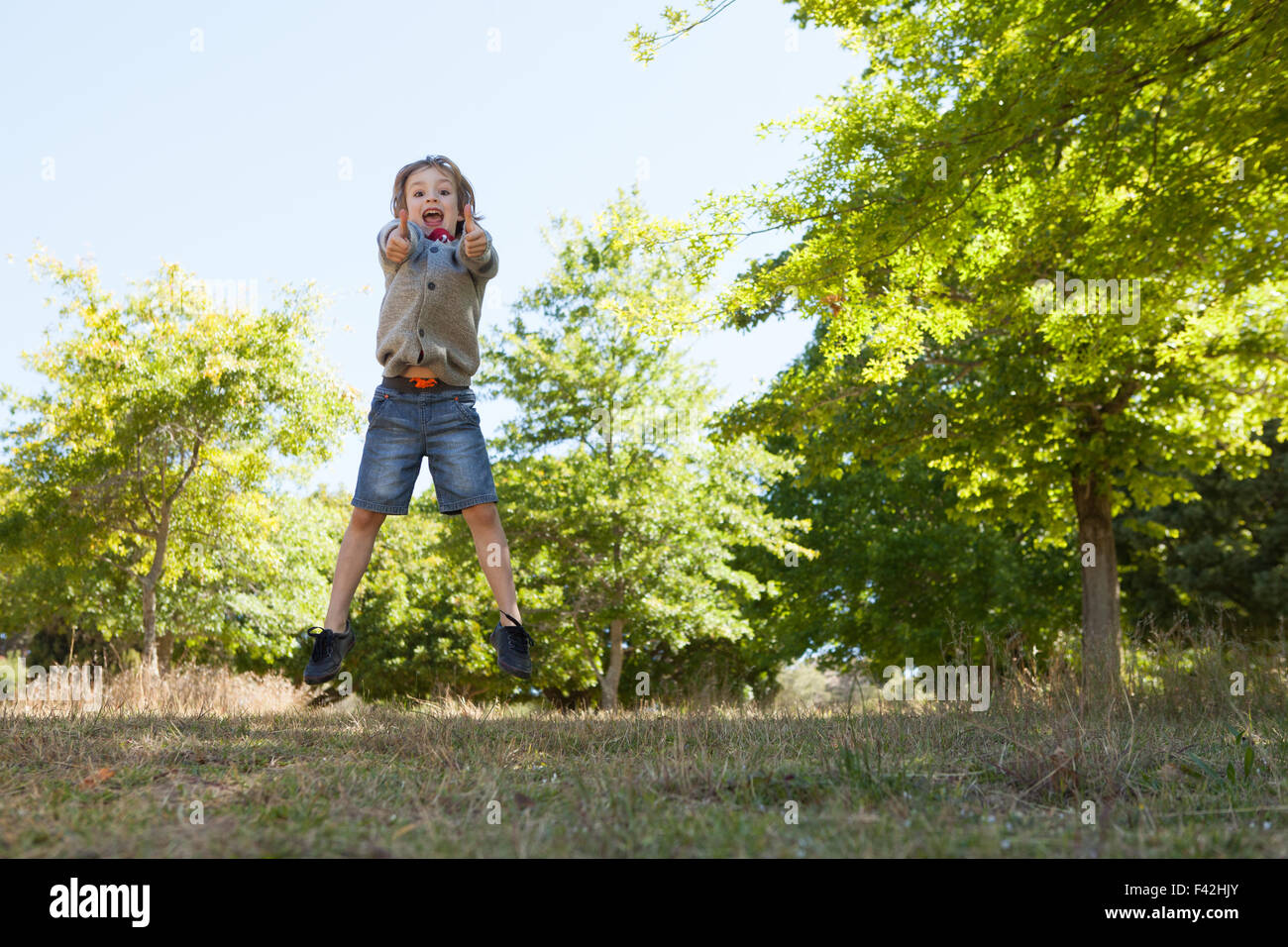 Cute little boy jumping in park Stock Photo - Alamy