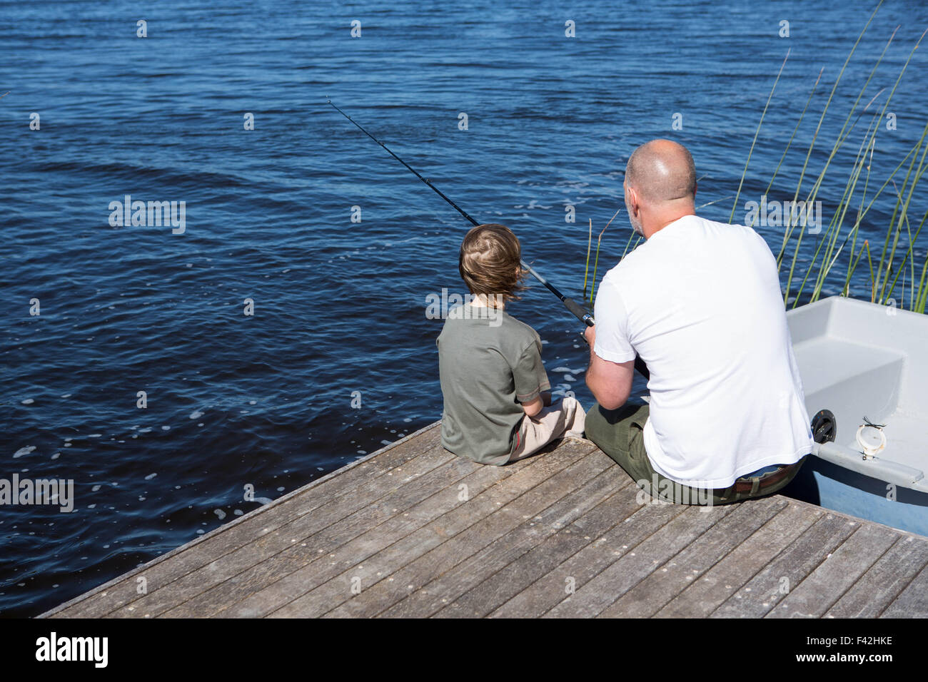 Happy man fishing with his son Stock Photo - Alamy