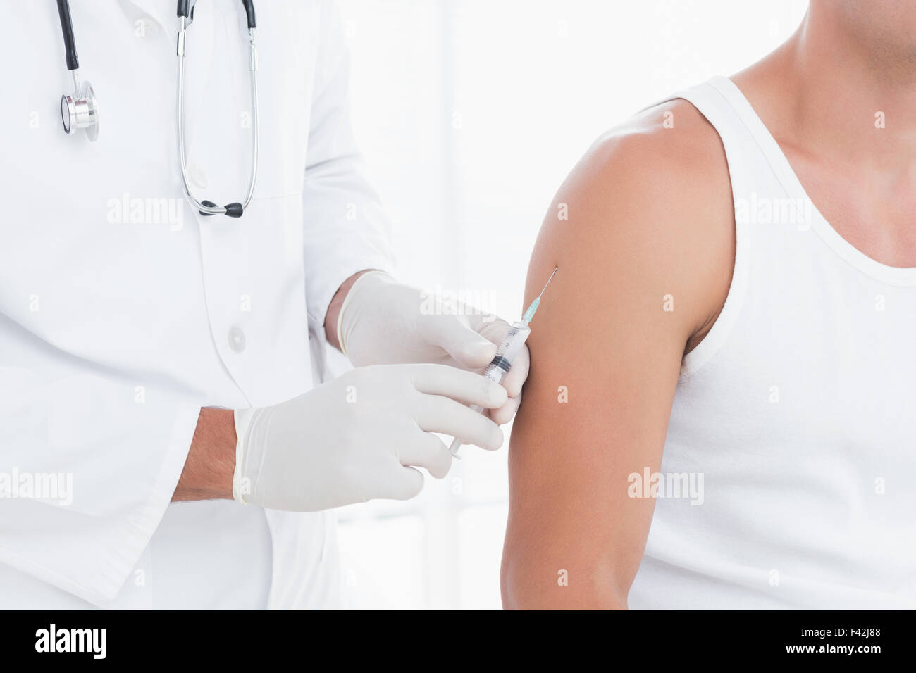 Doctor doing an injection to his patient Stock Photo - Alamy