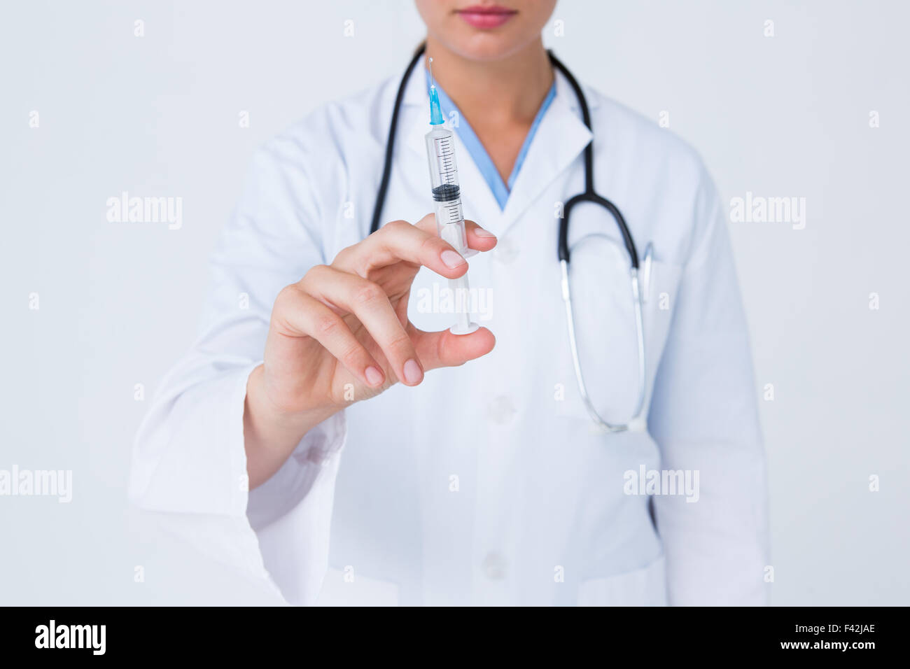 Doctor showing syringe to camera Stock Photo - Alamy