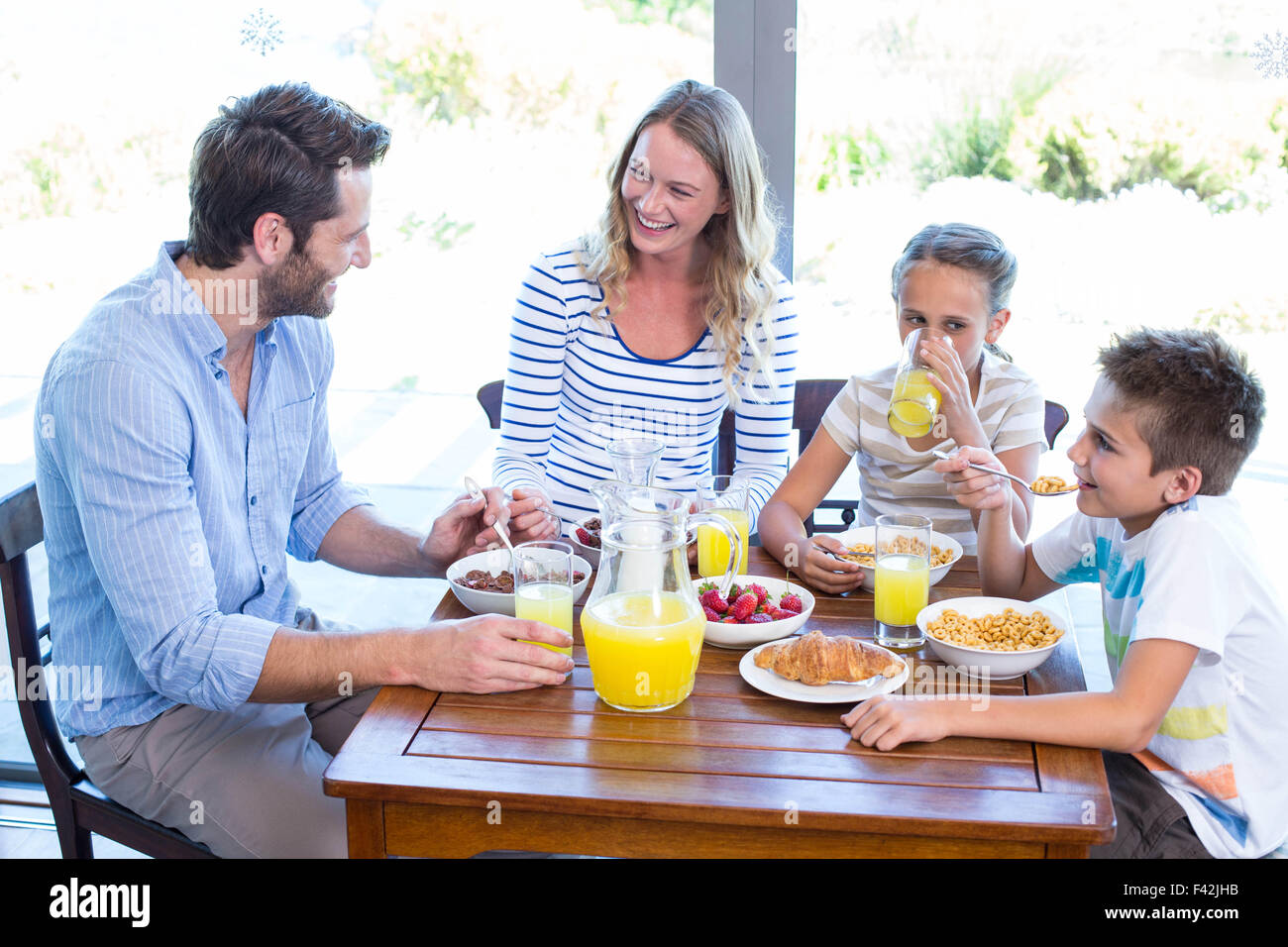 Happy family having breakfast together Stock Photo - Alamy