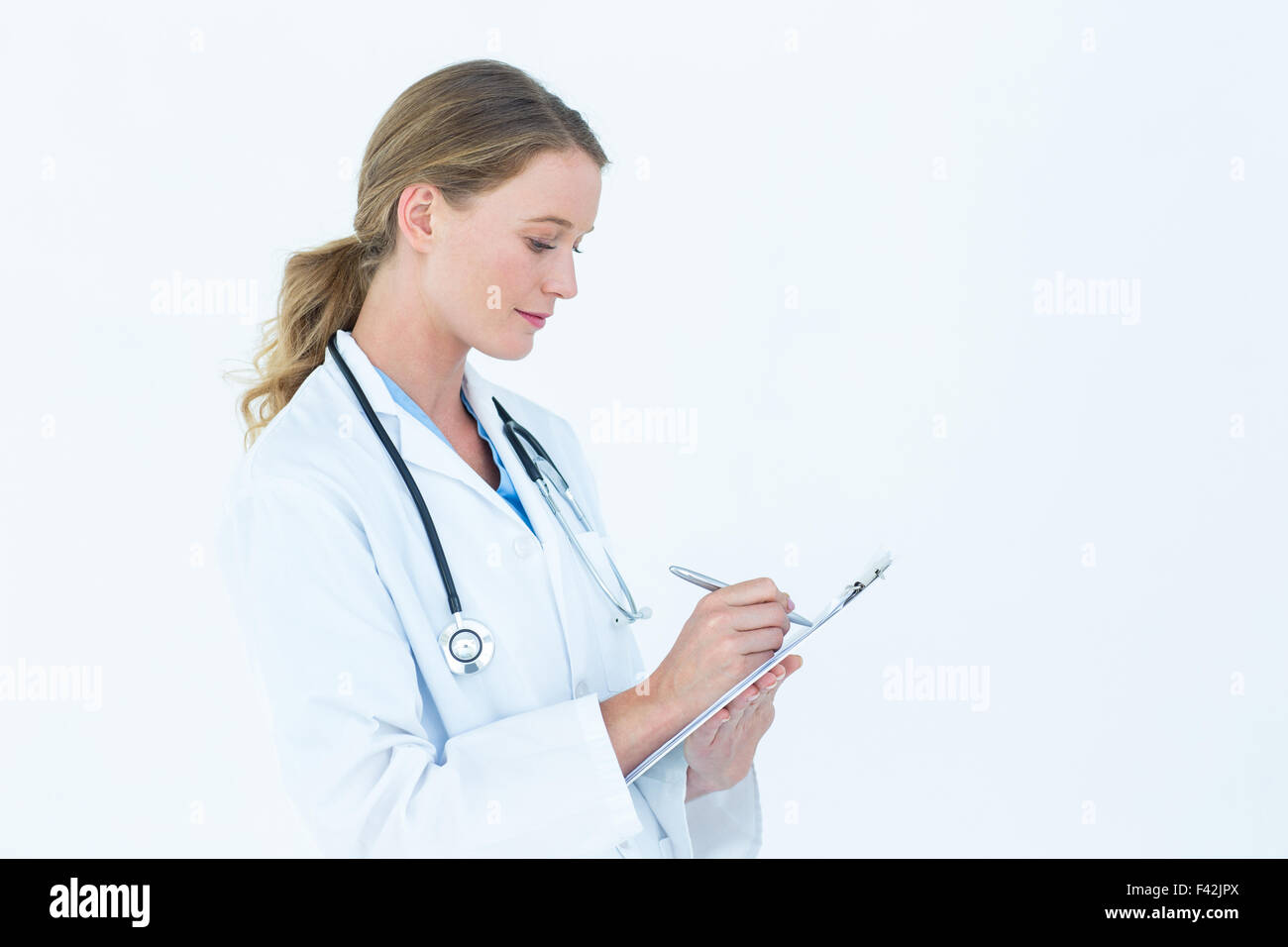 Doctor writing on clipboard Stock Photo - Alamy