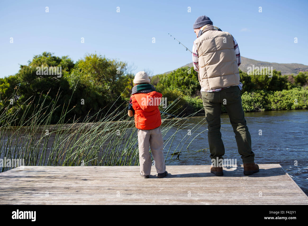 Happy man fishing with his son Stock Photo - Alamy