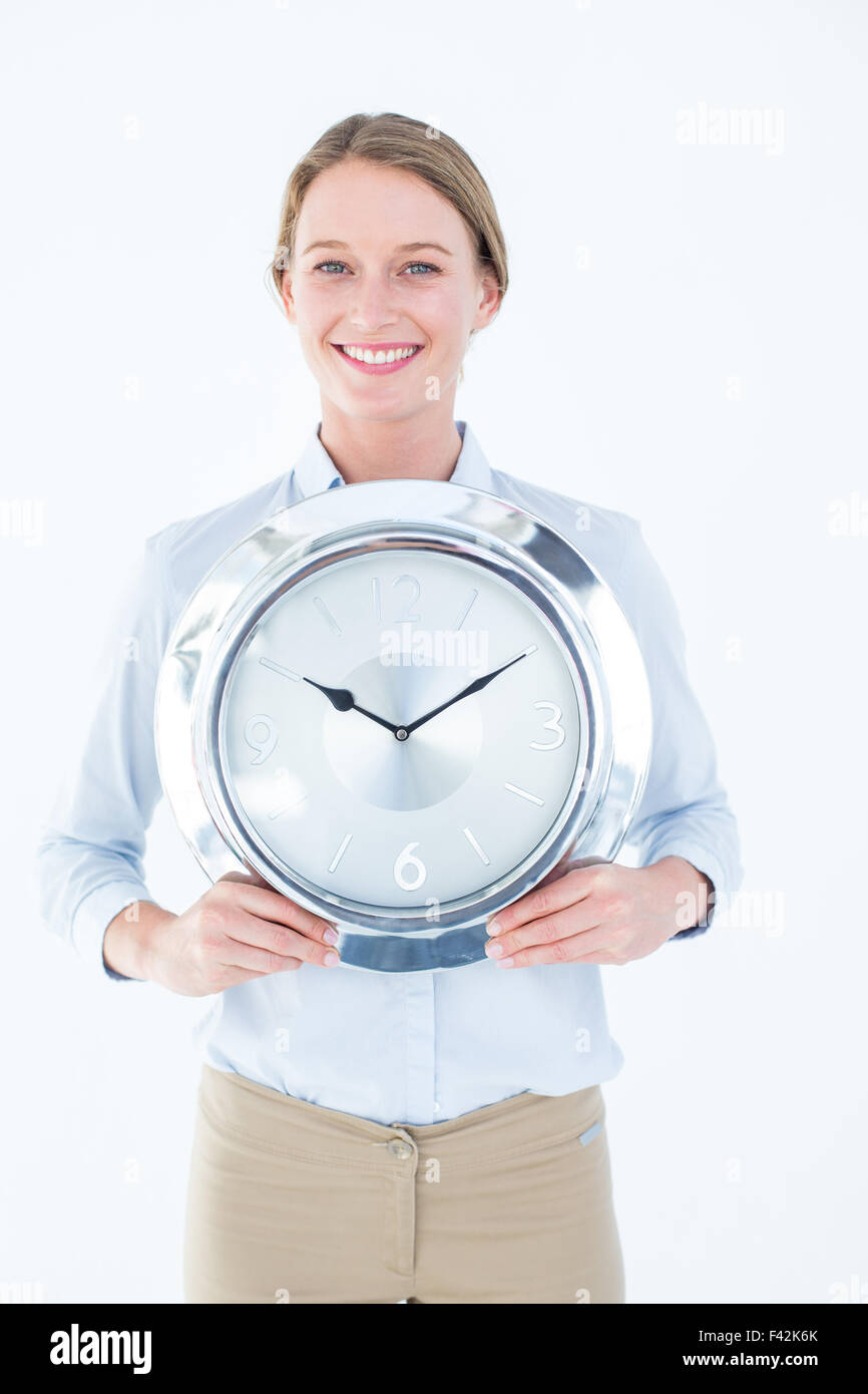 Businesswoman in suit holding a clock Stock Photo - Alamy
