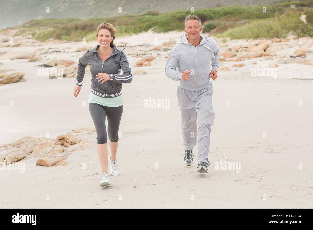 Fit couple jogging to camera Stock Photo - Alamy