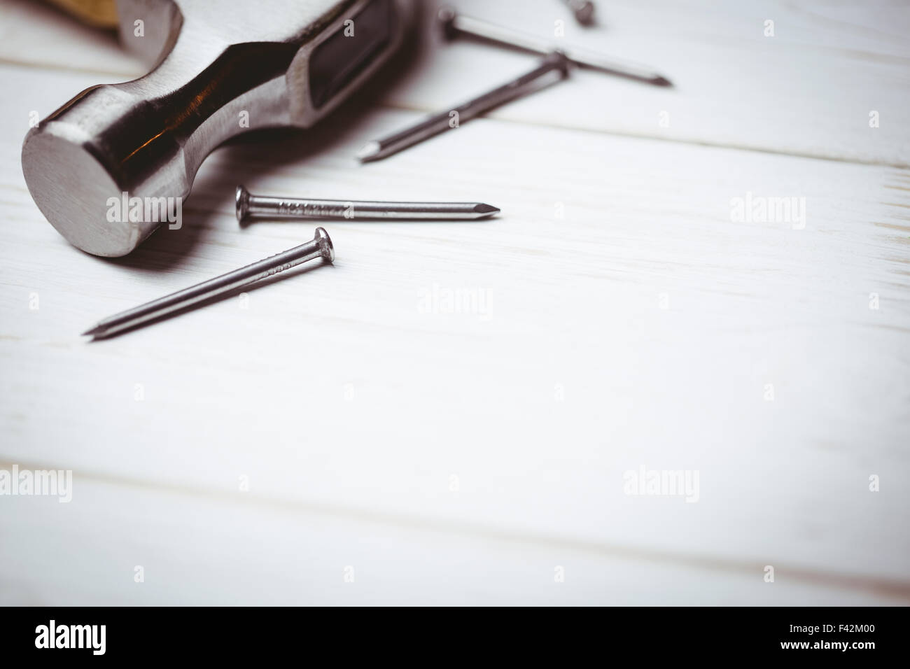 Hammer and nails laid out on table Stock Photo - Alamy