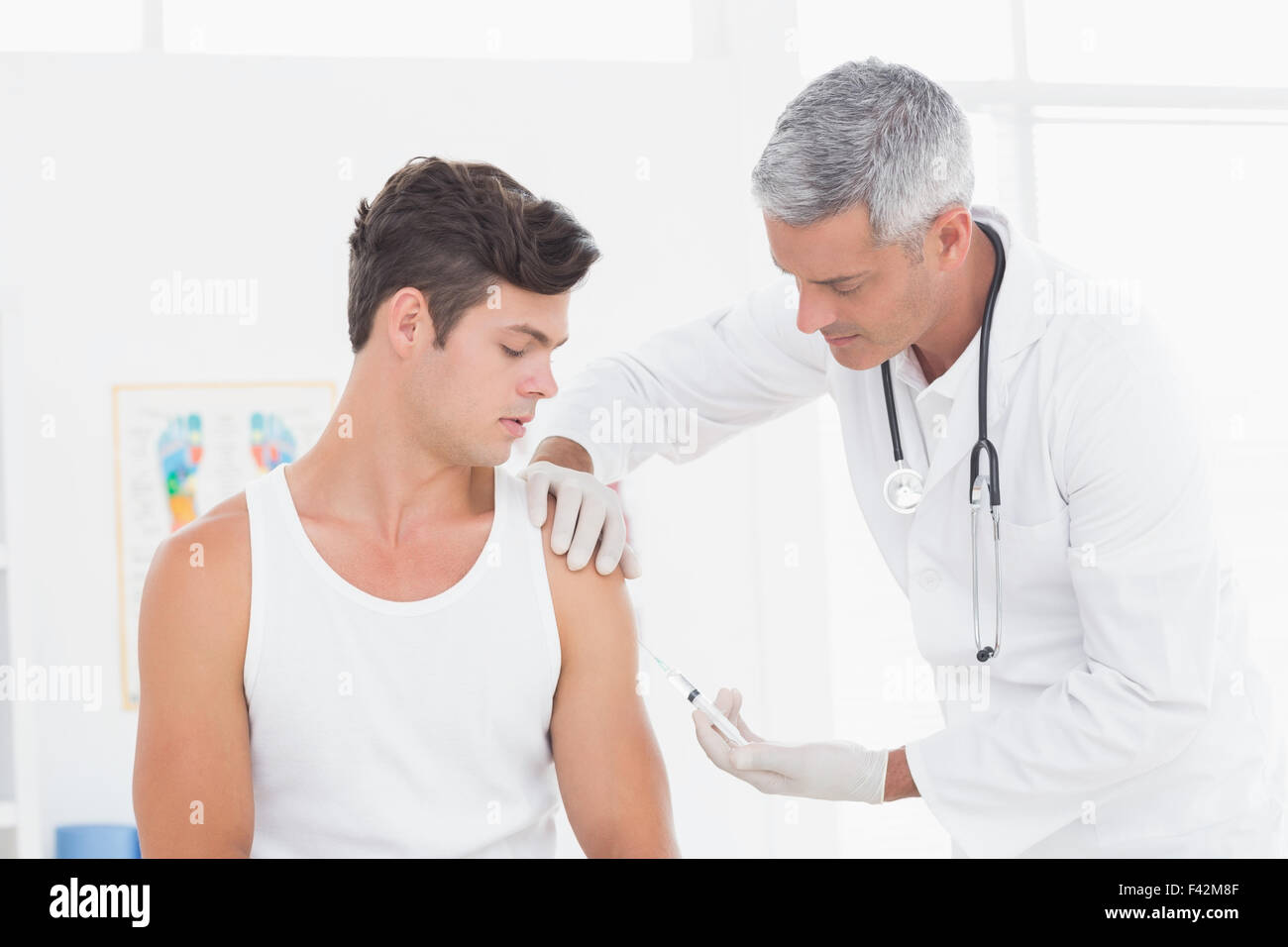 Doctor doing an injection to his patient Stock Photo - Alamy