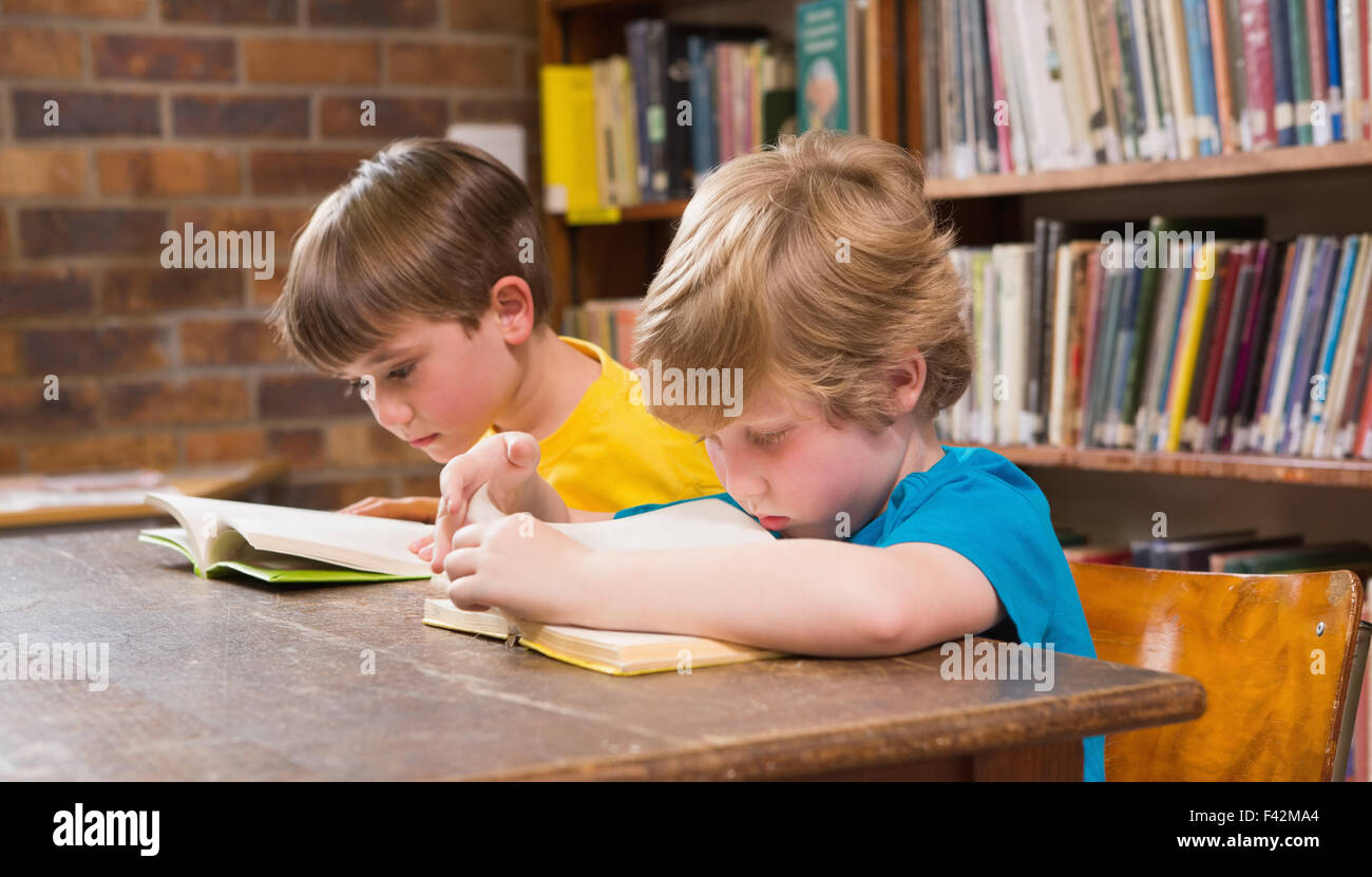 Cute pupils reading in library Stock Photo - Alamy