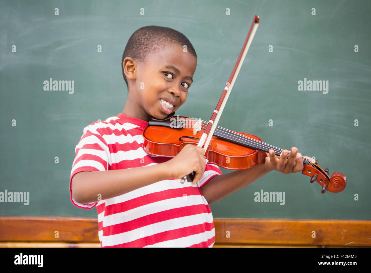 Happy pupil playing violin in classroom Stock Photo - Alamy