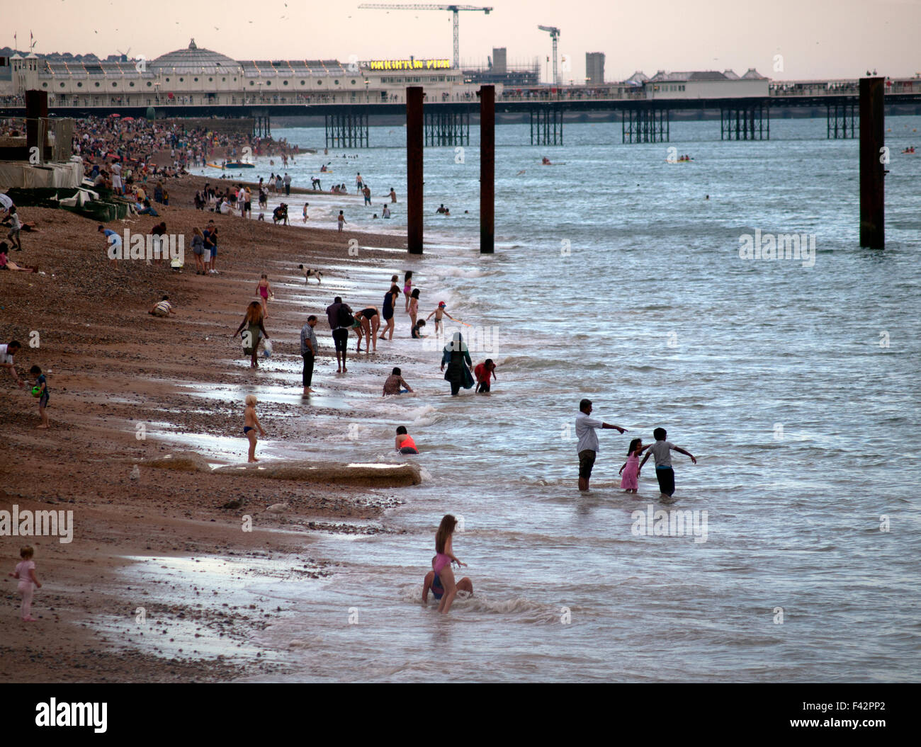 People having fun at the water's edge during a low tide in Brighton ...
