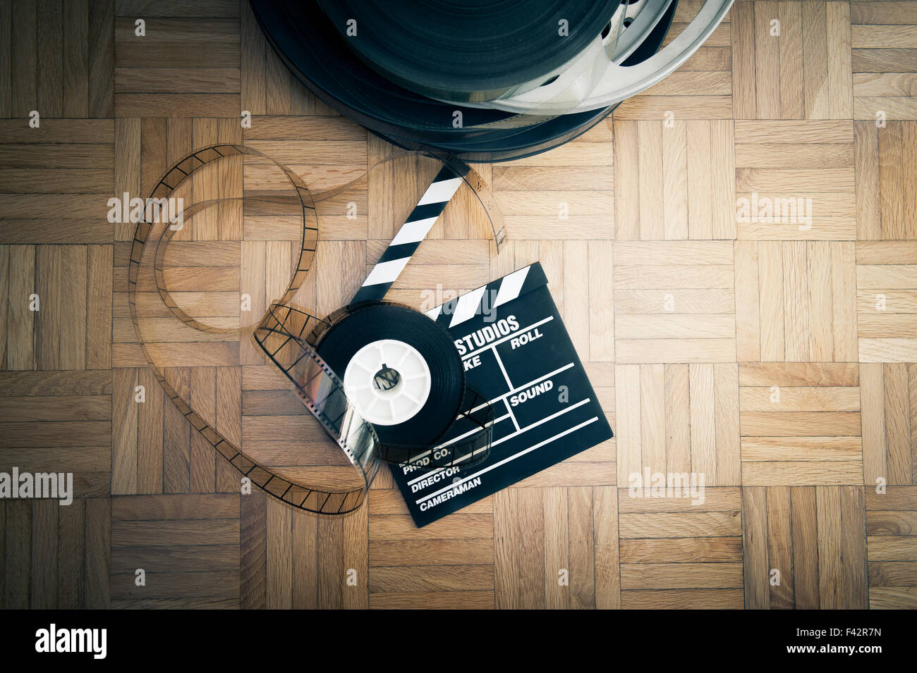 Cinema movie clapper board and 35 mm film reel on wooden floor vintage ...