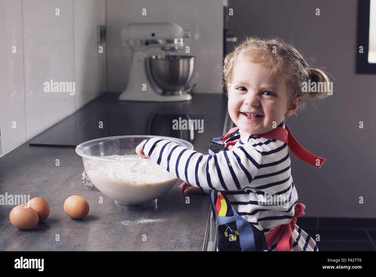 Little girl mixing batter, smiling, portrait Stock Photo - Alamy