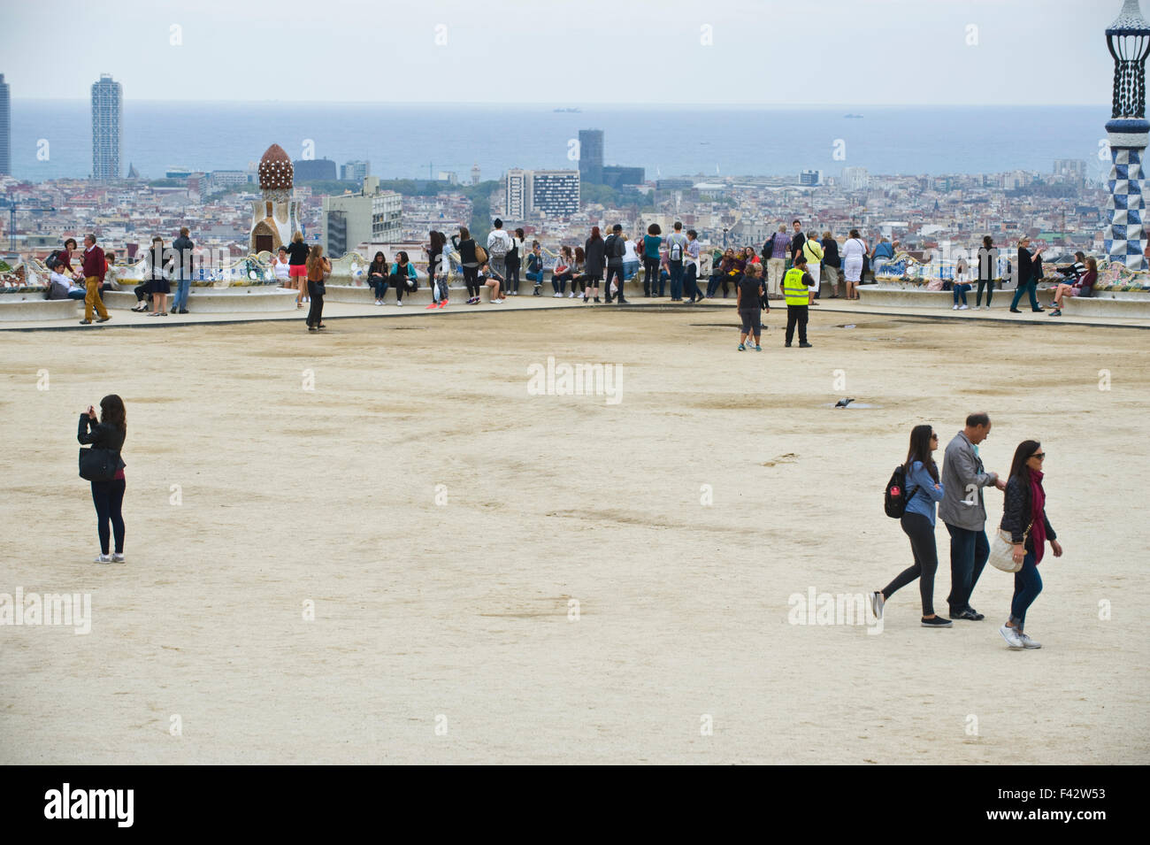 Serpentine bench with tourists & view over Barcelona at Gaudi's Park ...