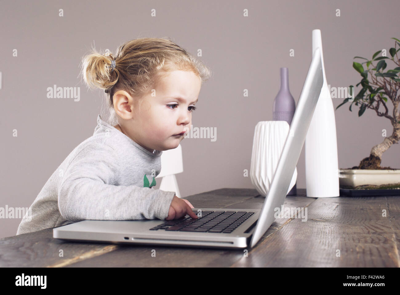 Little girl using laptop computer Stock Photo - Alamy