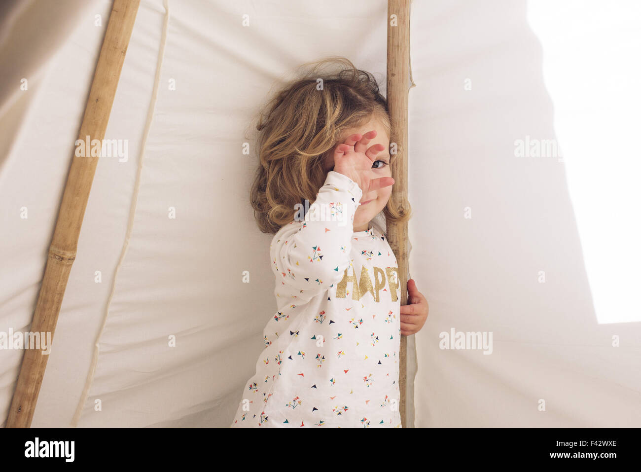 Little girl covering face with hand, smiling shyly Stock Photo - Alamy