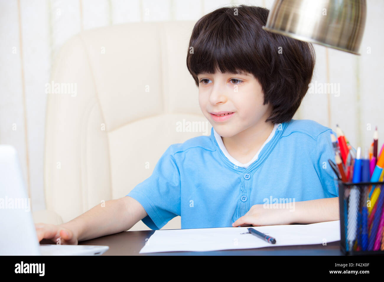 boy doing homework with computer Stock Photo - Alamy