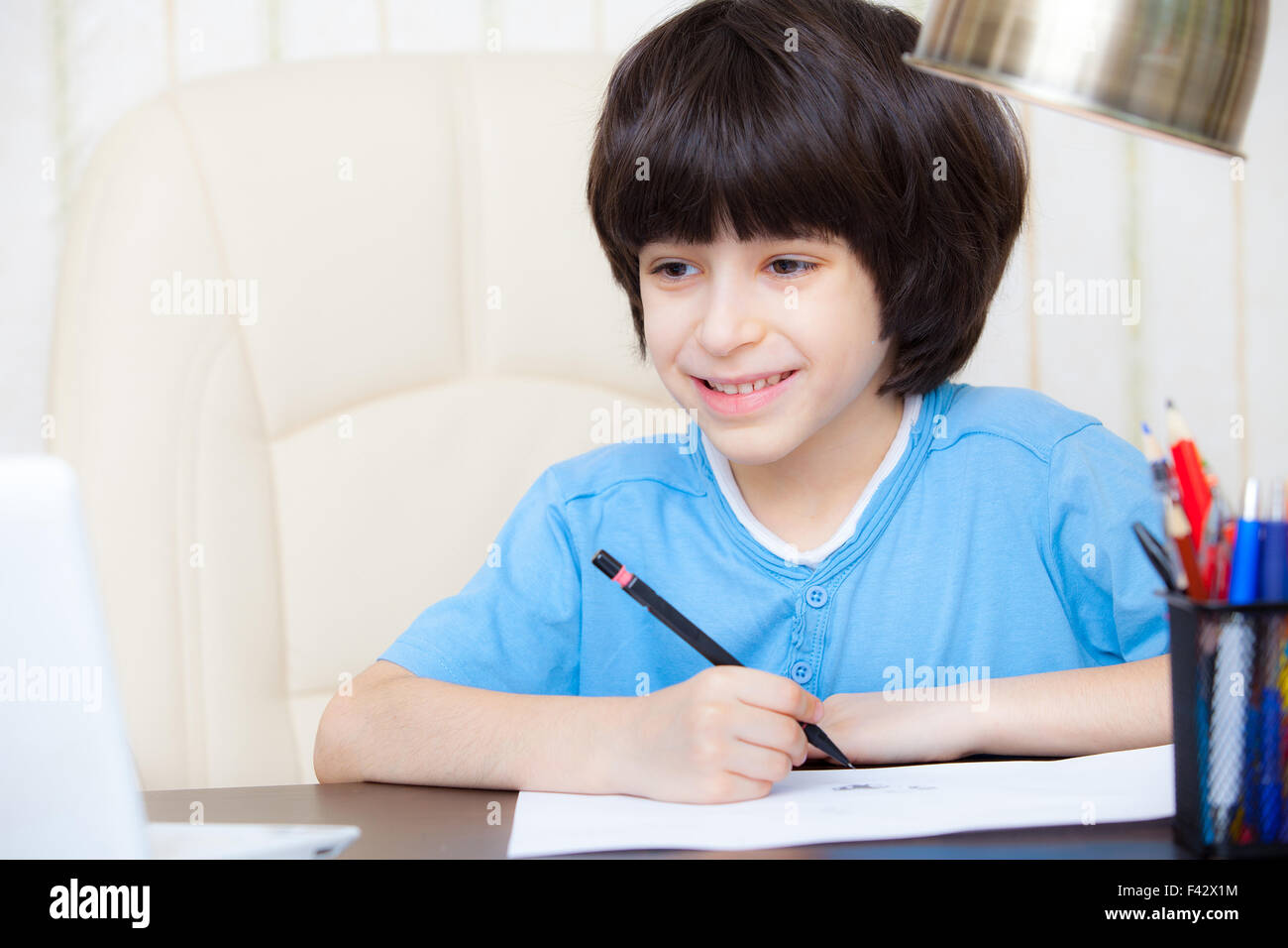smiling child doing homework with computer Stock Photo - Alamy