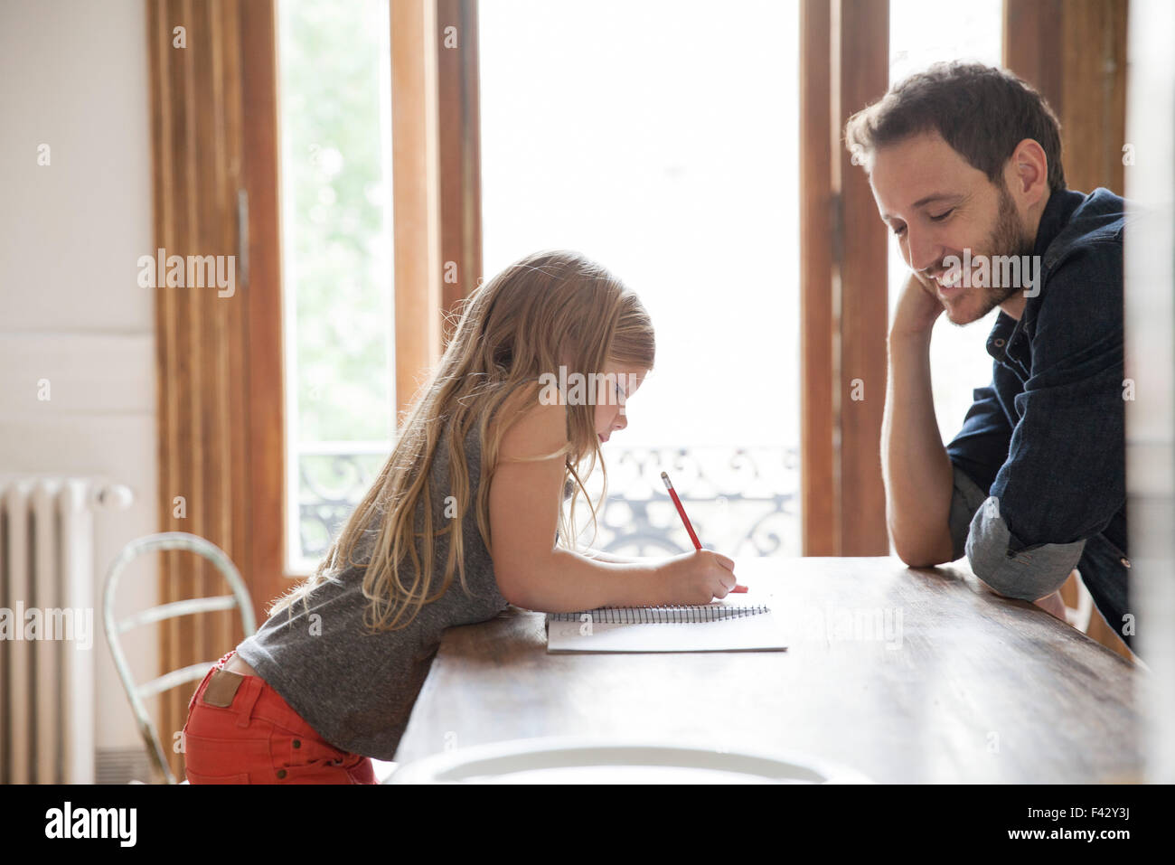 Father helping daughter practice writing Stock Photo - Alamy