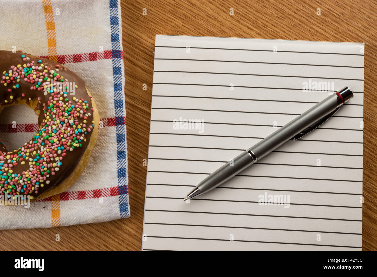 doughnut and notepad with pen Stock Photo - Alamy