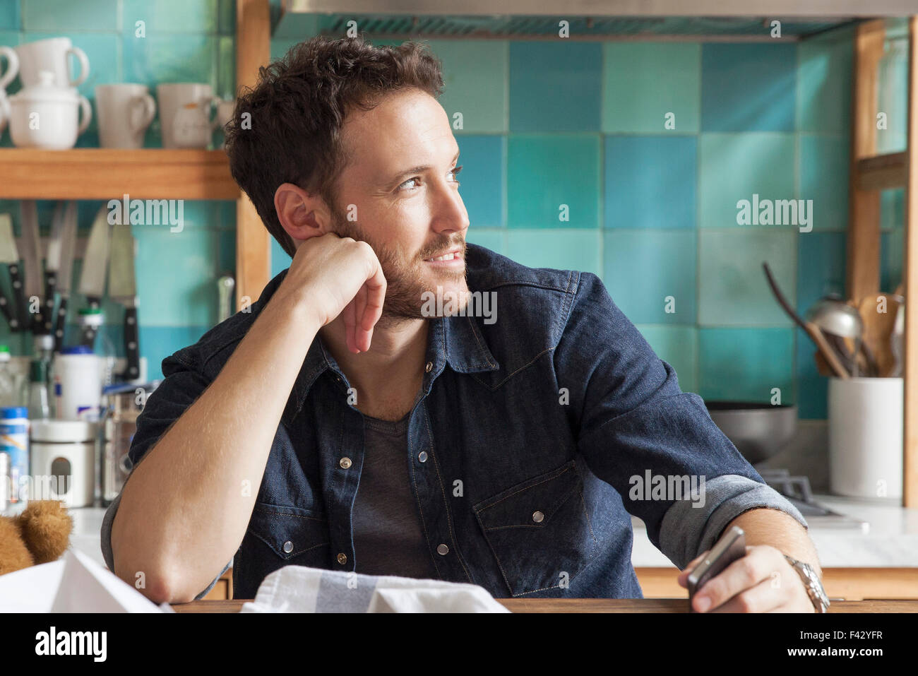 Man daydreaming in messy kitchen Stock Photo - Alamy